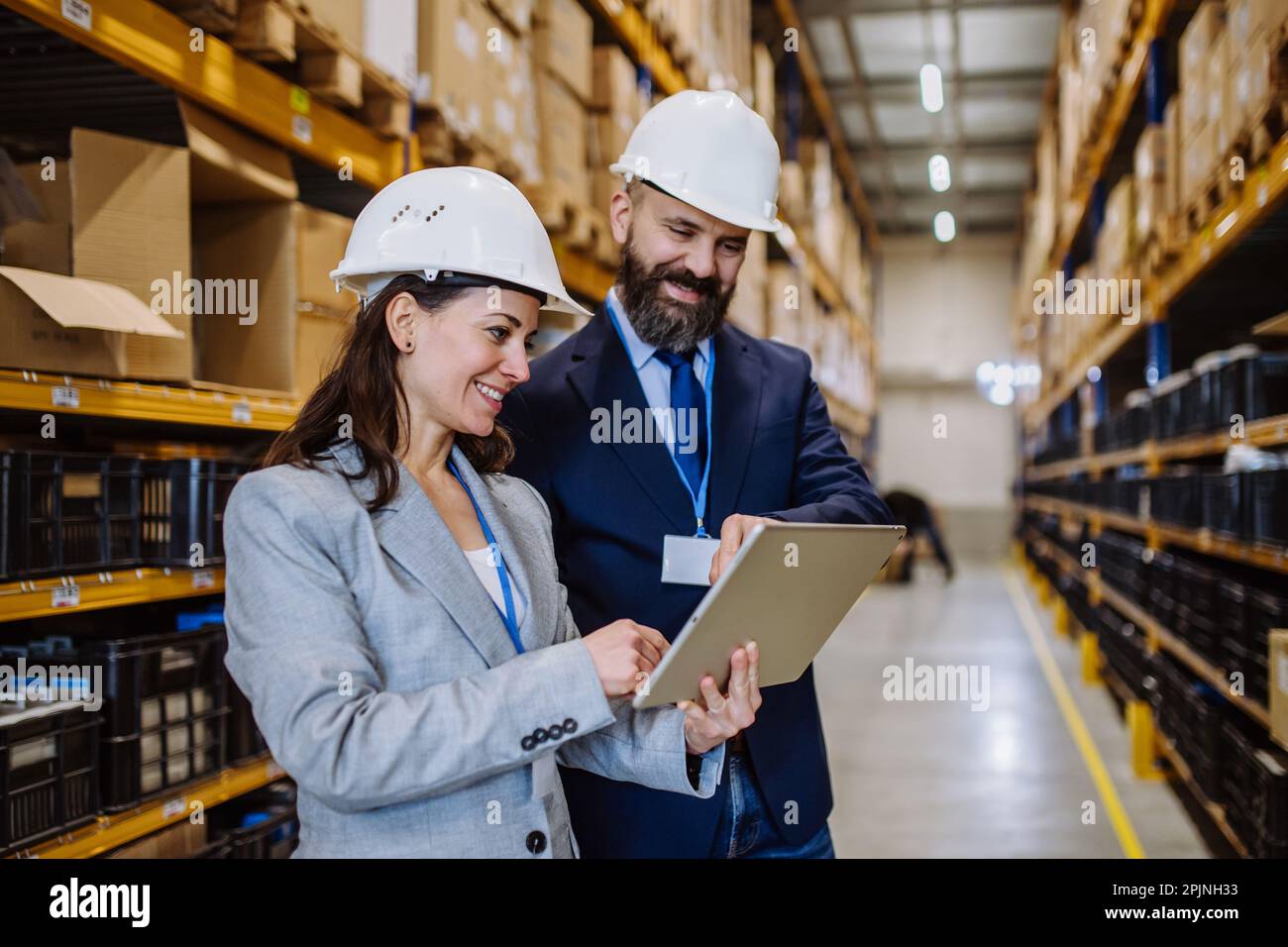 Managers in suit controlling goods in a waehouse Stock Photo - Alamy