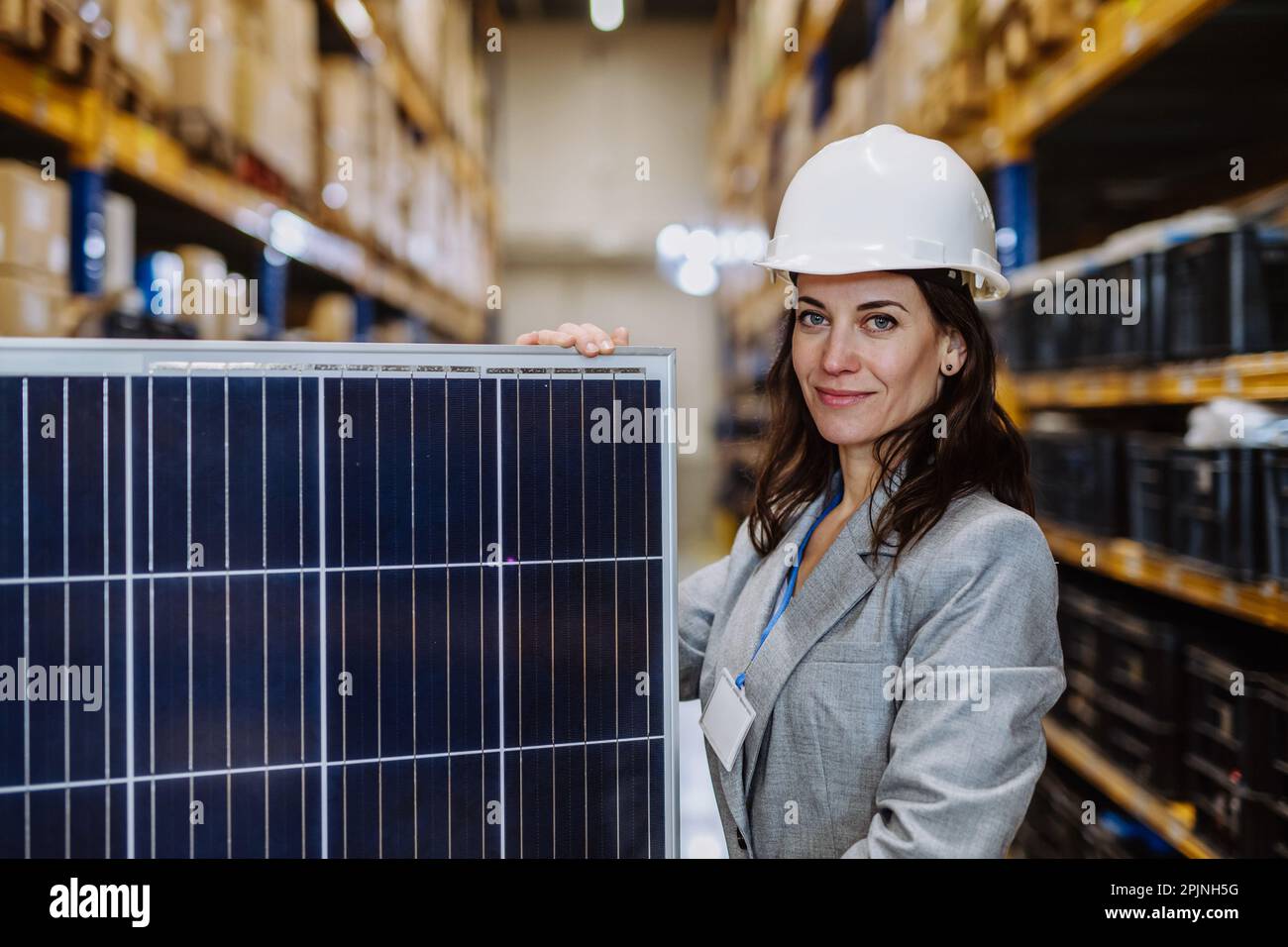 Portrait of manager holding a solar panel in a warehouse Stock Photo ...