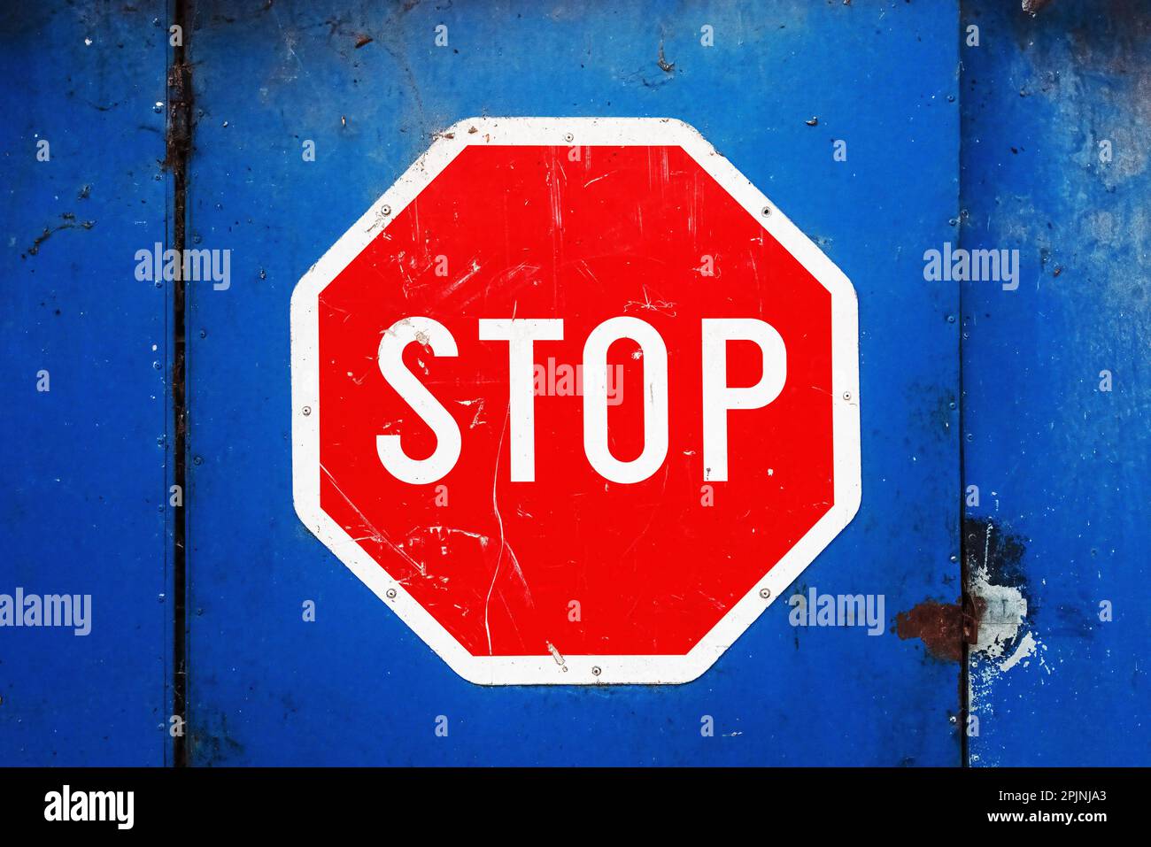 Stop sign on blue garage door with vignette Stock Photo - Alamy