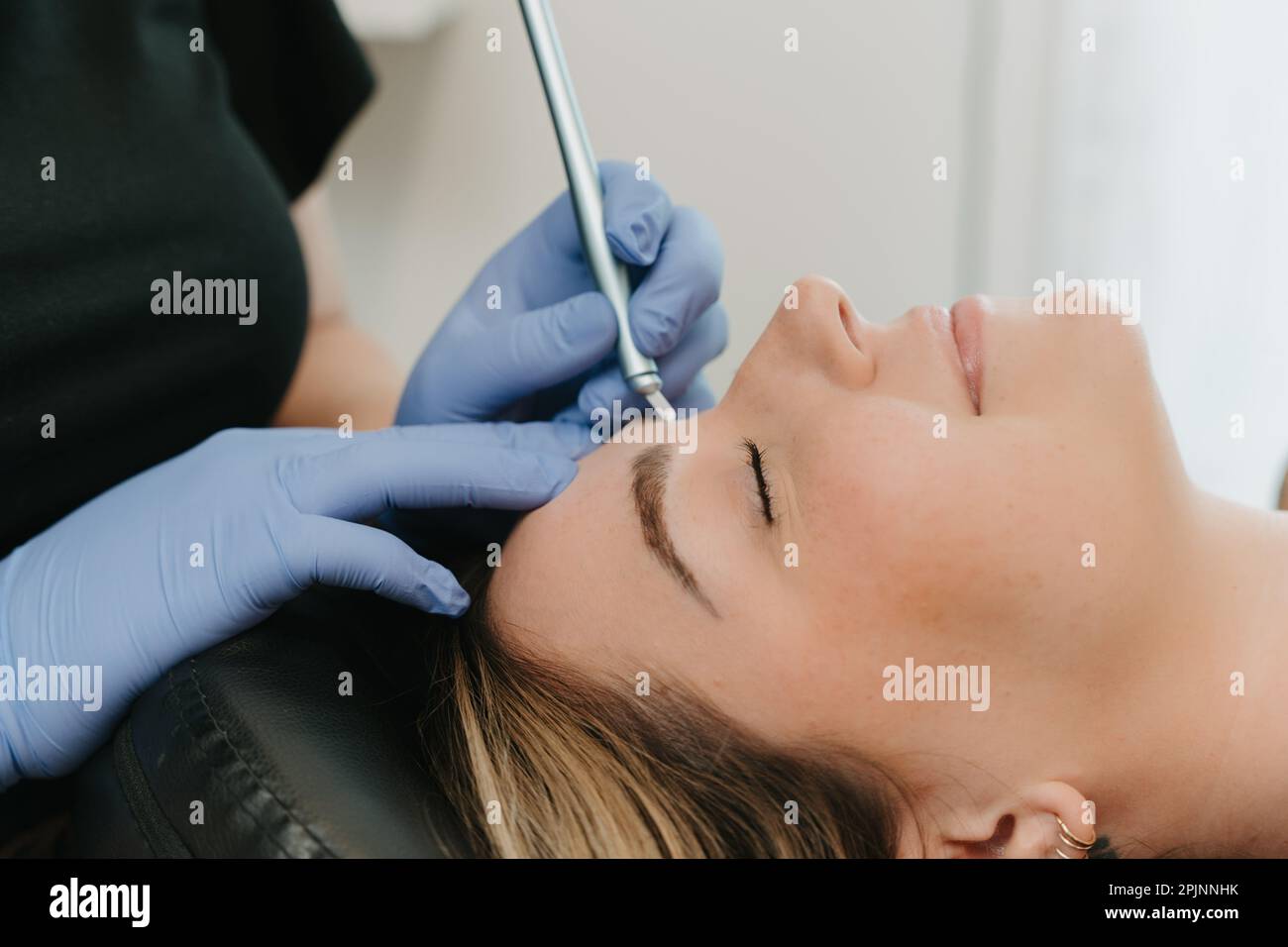 Woman receiving microblading on her eyebrows by esthetician Stock Photo ...