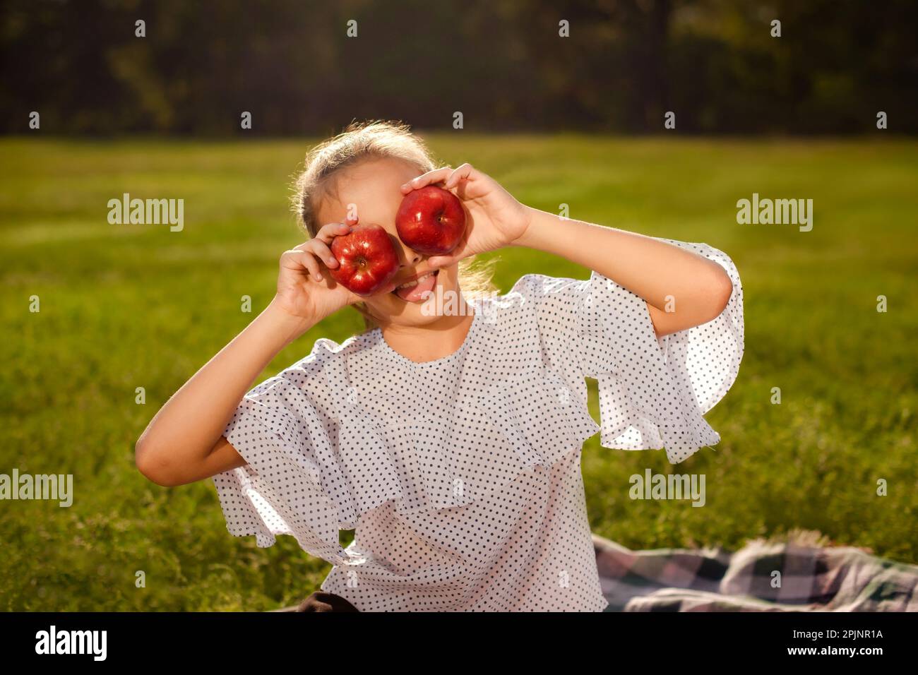 happy child girl play with apples in summer green park. Funny child ...