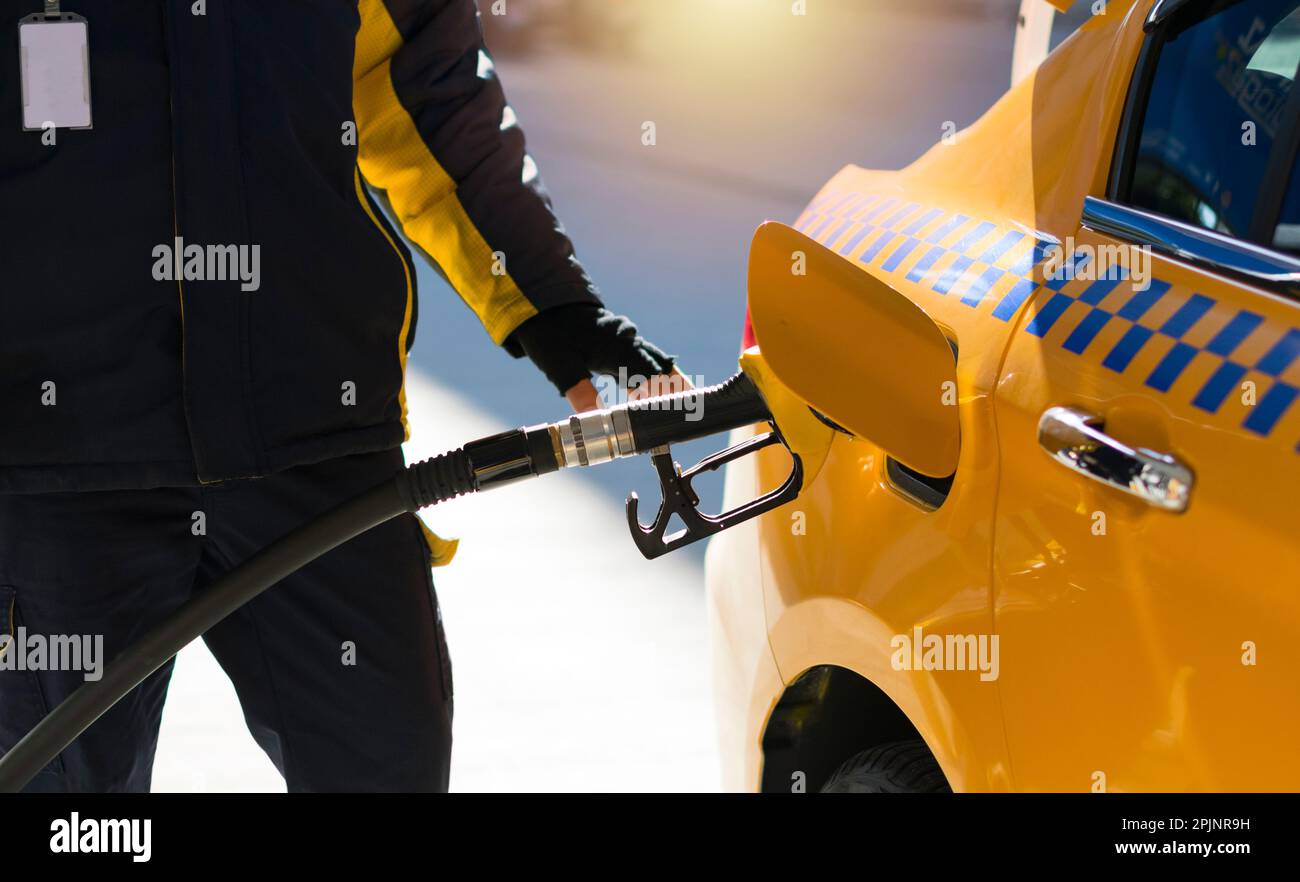 Taxi at gas station being filled with fuel on Turkey. The driver hands ...