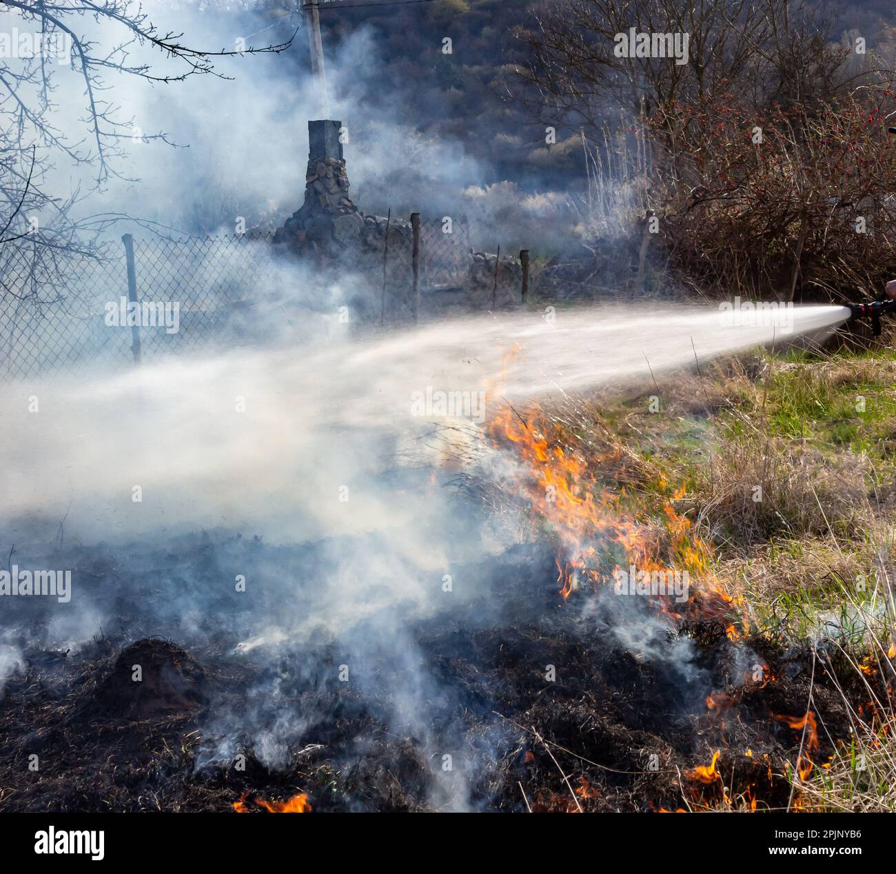 spring fire, burning dry grass near buildings in the countryside ...