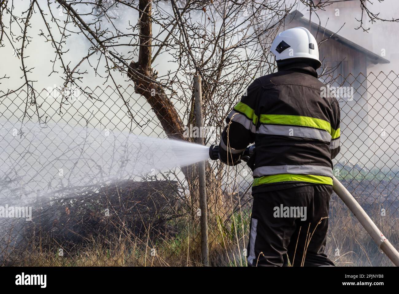 spring fire, burning dry grass near buildings in the countryside ...