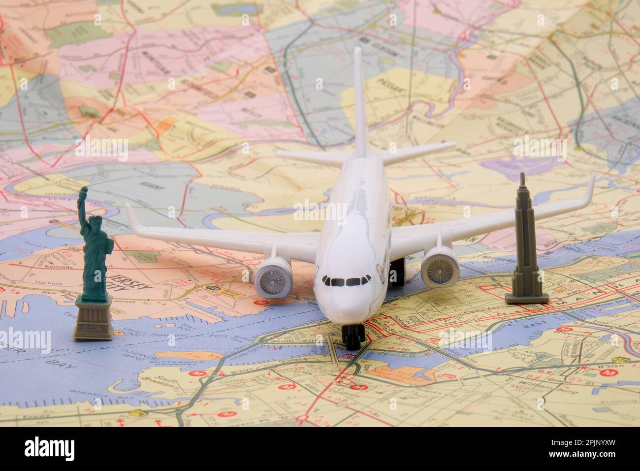Close up detail of a miniature passenger plane on a colorful map of New ...