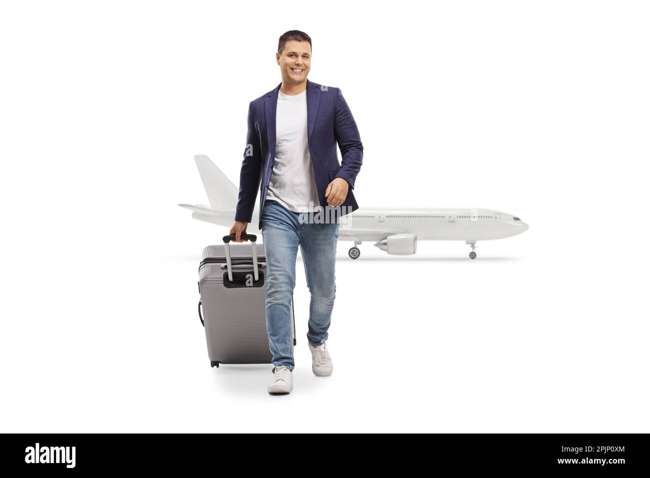 Full length portrait of a man smiling and pulling a suitcase in front ...