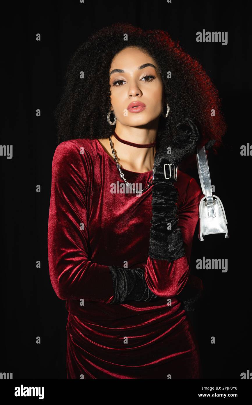 Fashionable african american model in burgundy dress and handbag ...