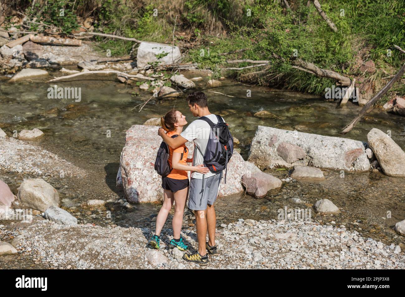 Two young hikers with backpacks, a couple in love xploring nature Stock ...