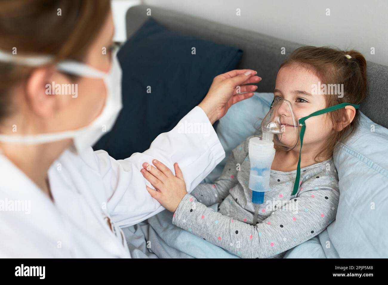 Doctor visiting little patient at home. Child having medical inhalation ...
