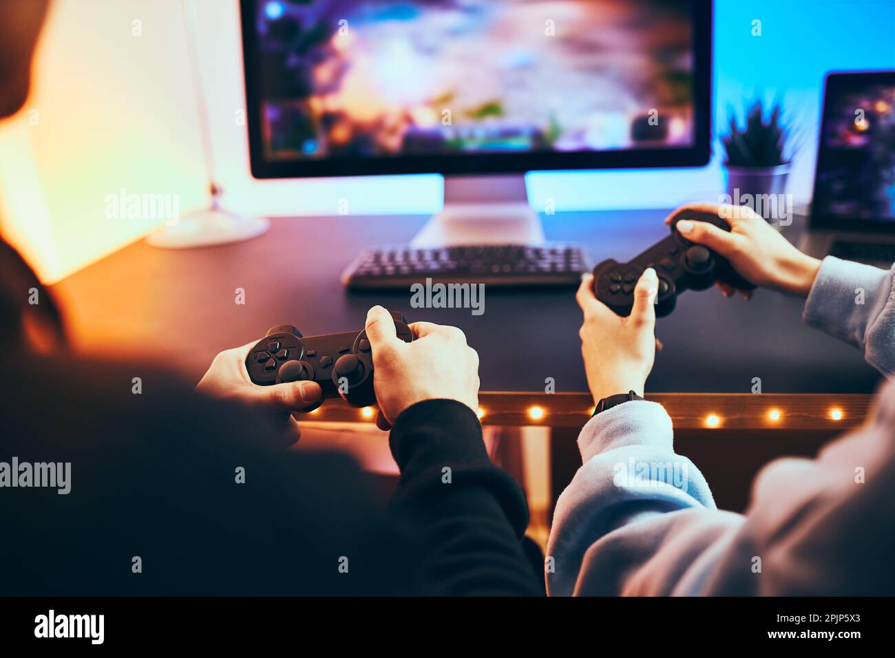 Friends playing video game at home. Gamers holding gamepads sitting at ...
