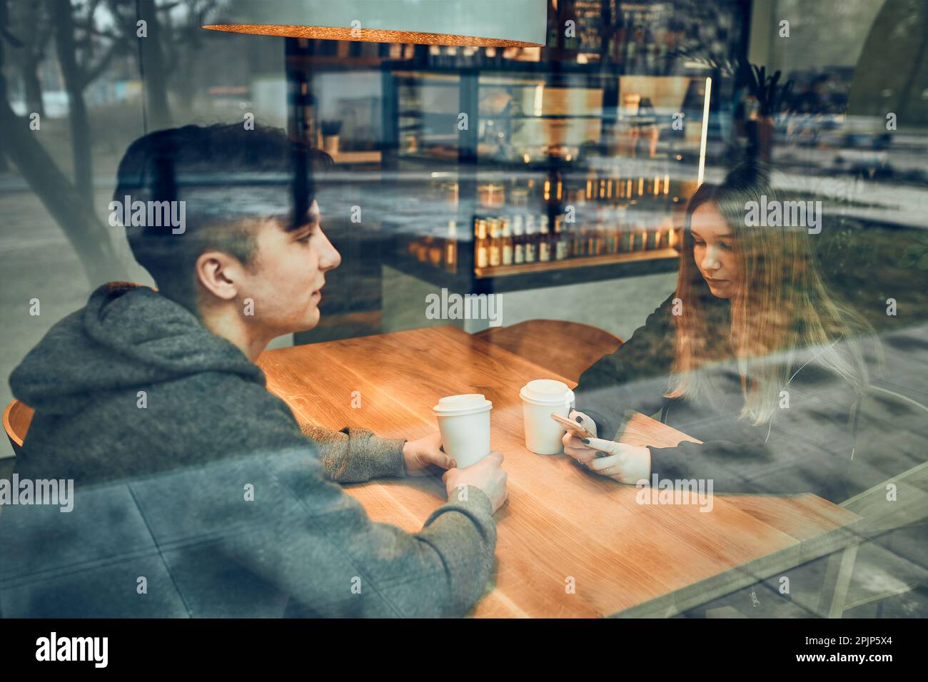 Friends having a chat, talking together, drinking coffee, sitting in a ...