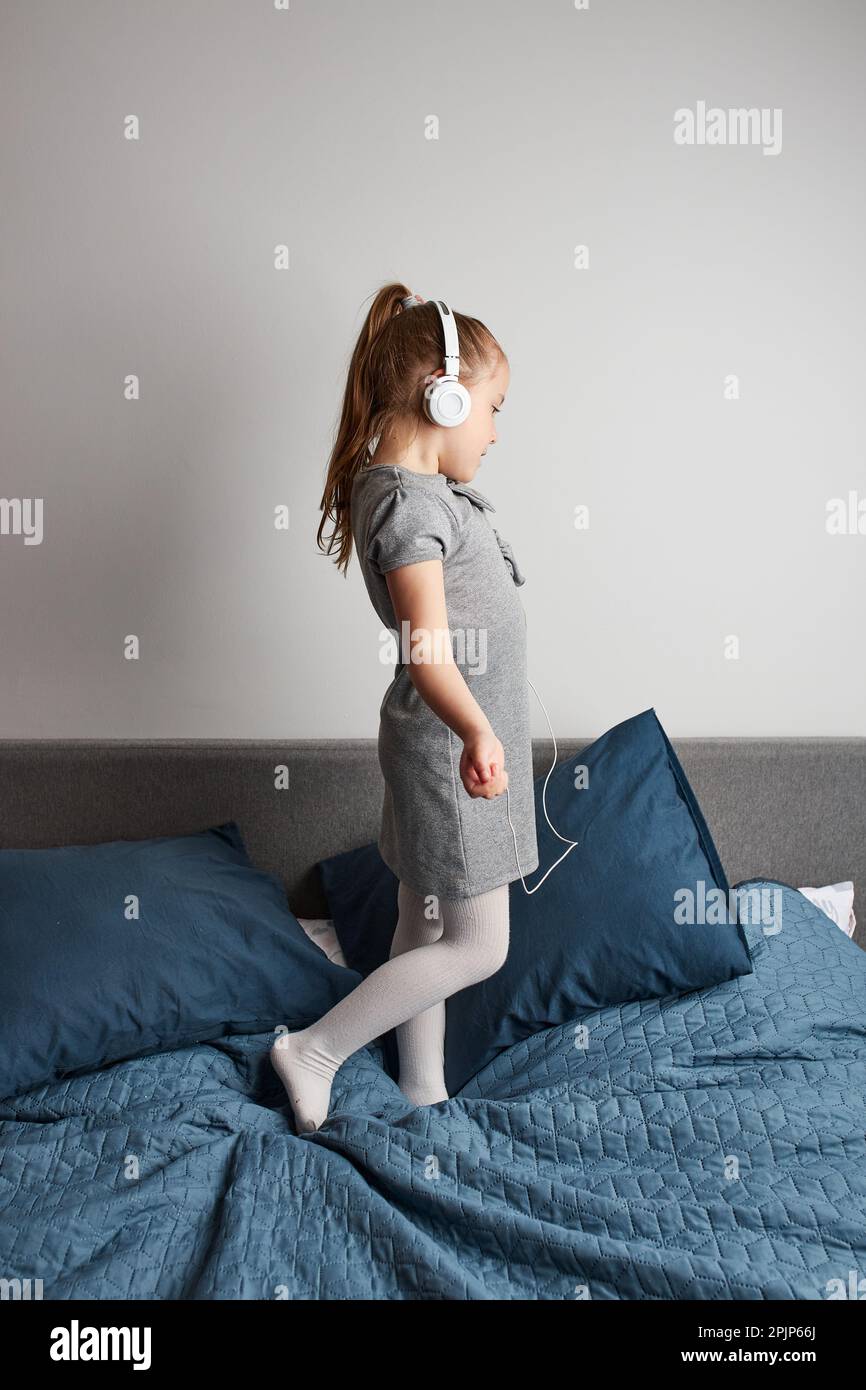 Little girl singing holding headphones cord imitating herself a real ...