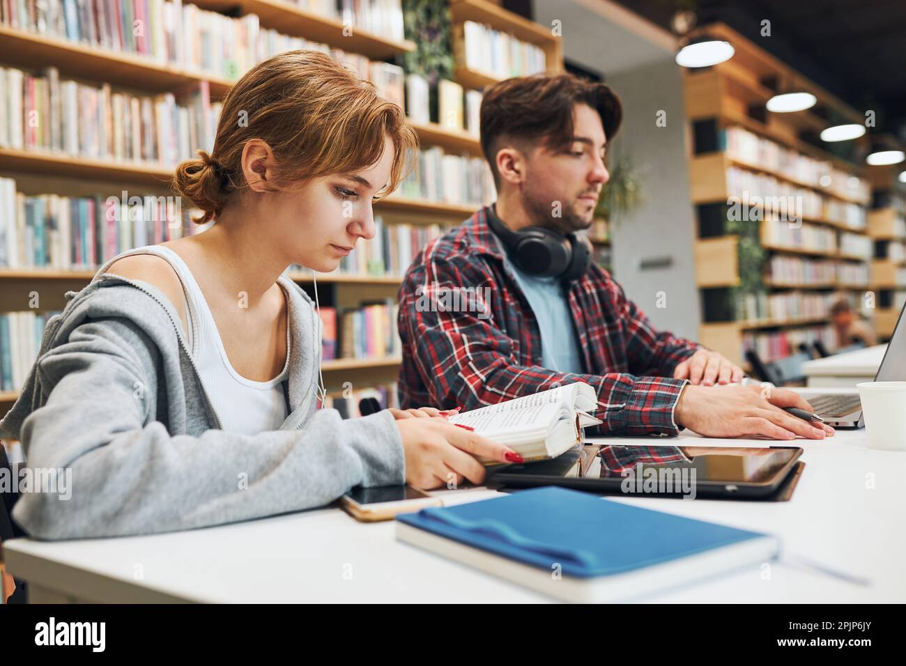 Students learning in university library. Young man preparing for test ...