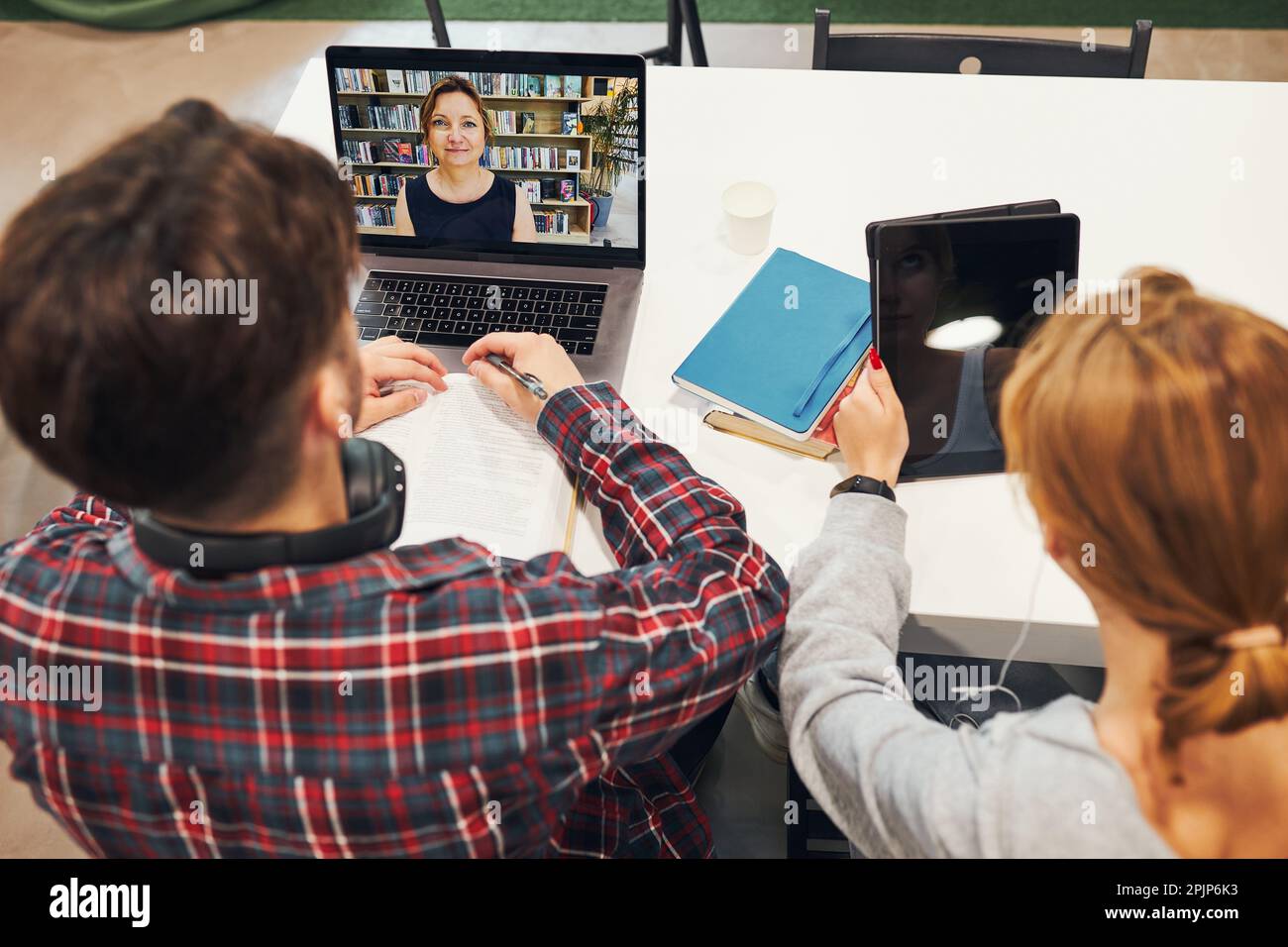 Students learning in university library. Young man having video class ...