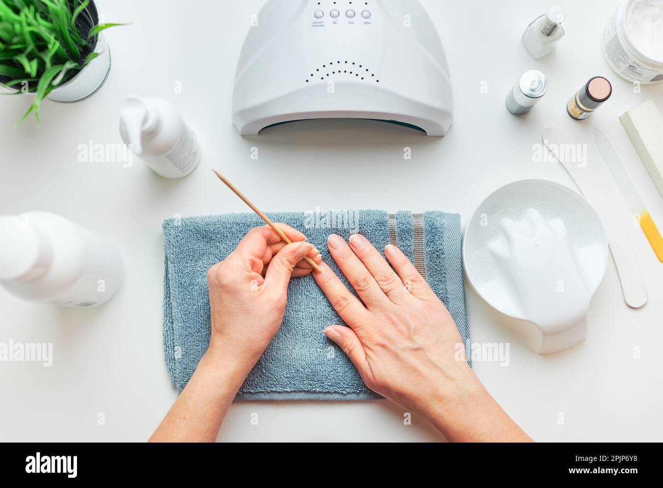 Woman preparing nails to apply gel hybrid polish using UV lamp. Beauty ...