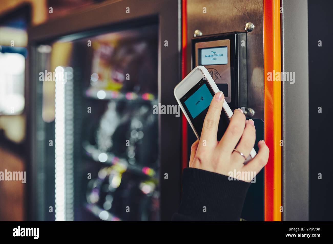 Woman paying for product at vending machine using contactless method of ...