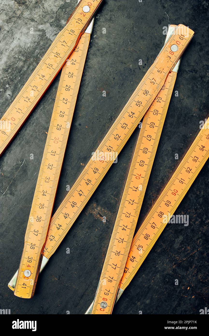 Wooden measure. Old ruler on metal surface. Measuring tool. Technical ...