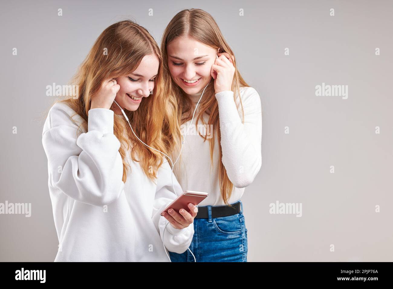 Young women girls listening to music together streaming content having ...
