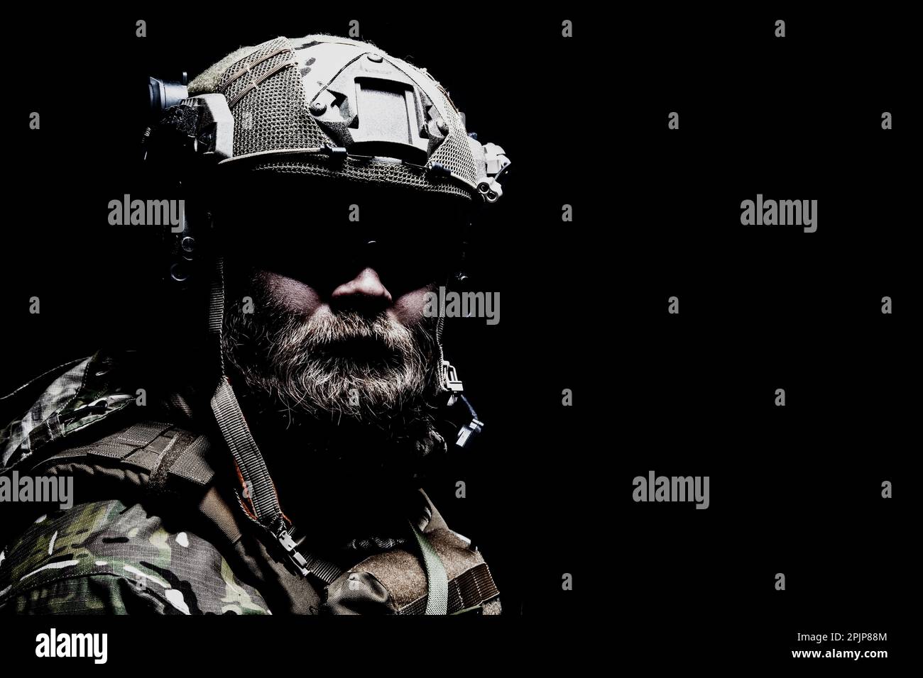 Close up, low key half length portrait of bearded commando fighter ...