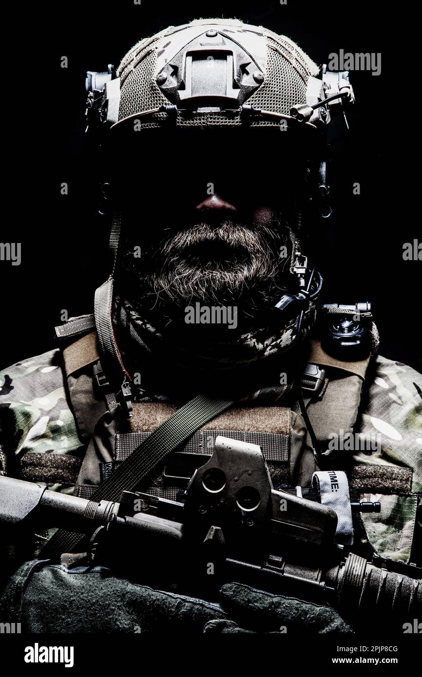 Close up, low key half length portrait of bearded commando fighter ...