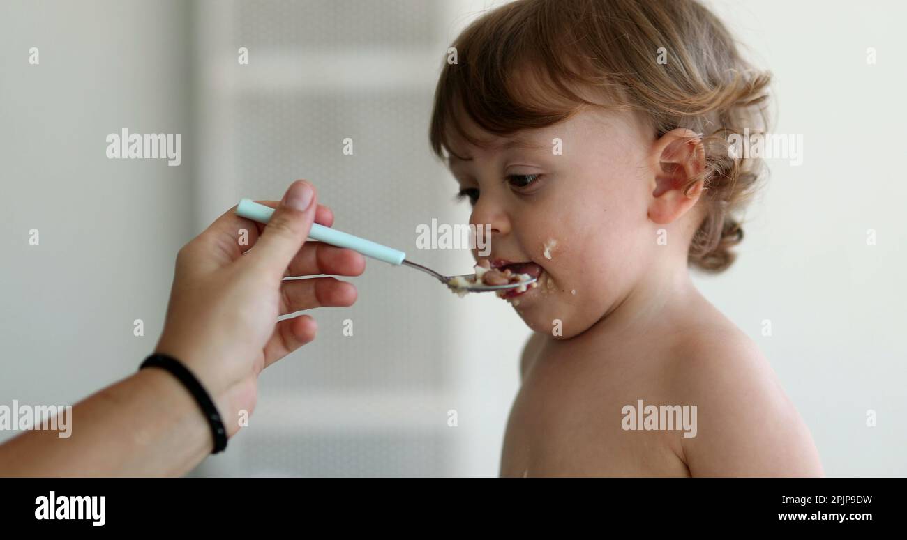 Cute baby child infant refusing spoon food Stock Photo - Alamy