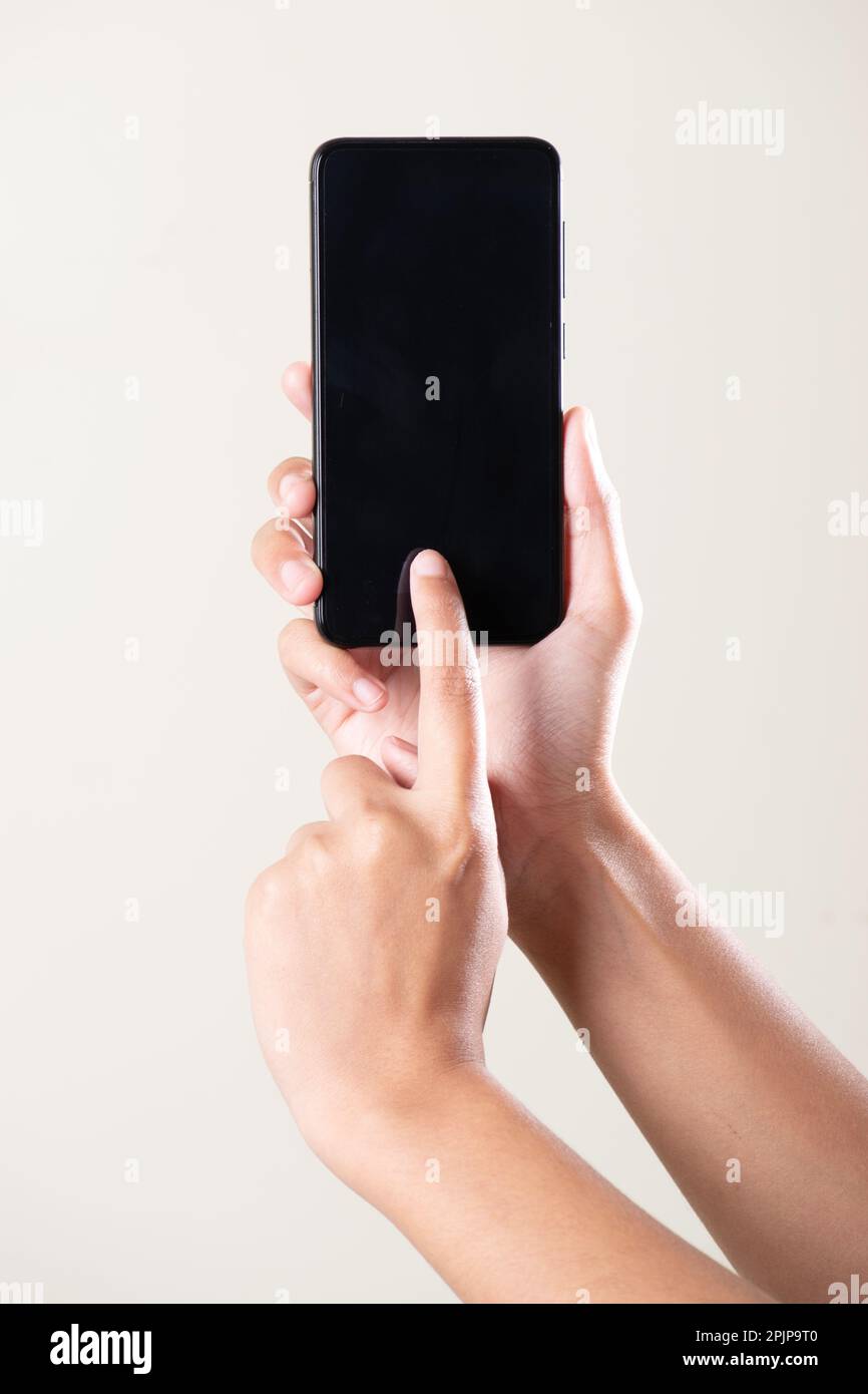 Black screen phone in hand using with finger on grey background Stock ...