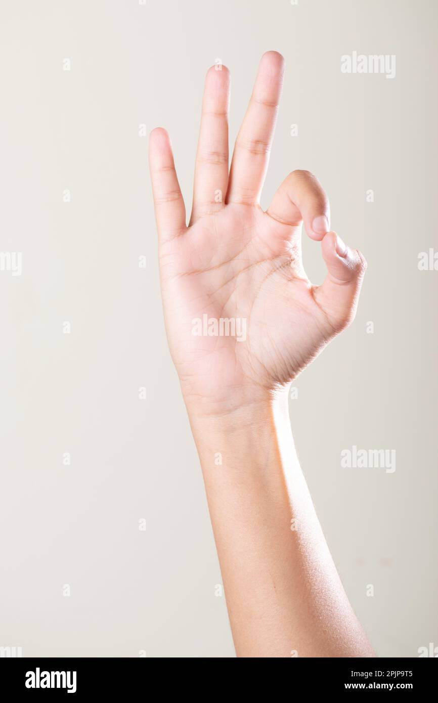 Female hand like gesture on grey background Stock Photo - Alamy