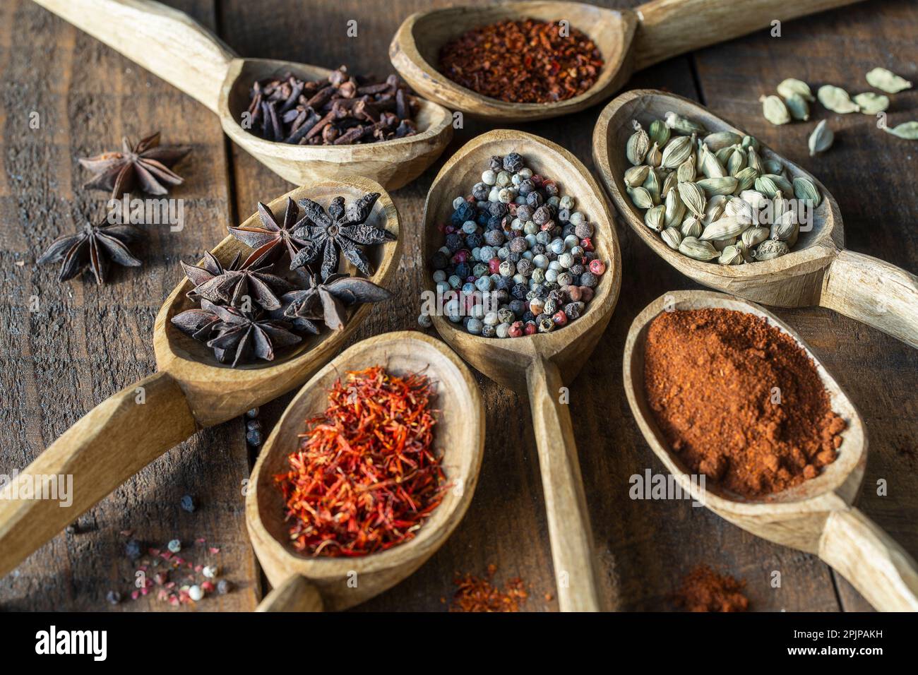 Set of spices in wooden spoons, close up, top view. Various pepper ...