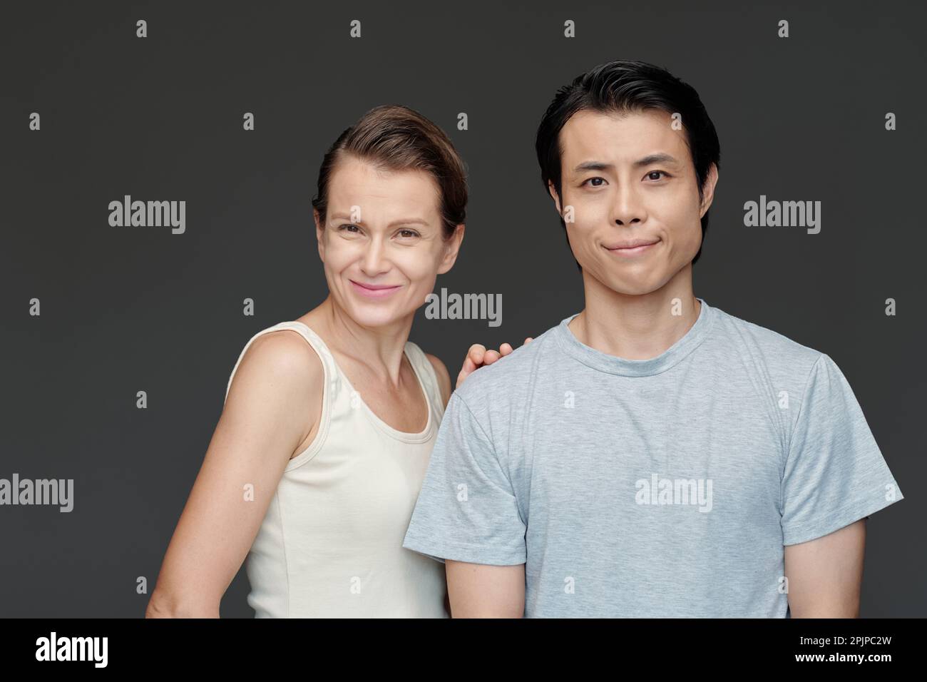 Studio portrait of diverse couple with age difference smiling at camera ...