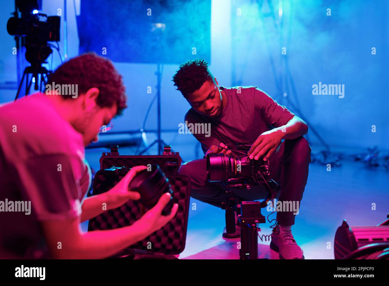 Two professional photographers setting cameras before shooting while ...