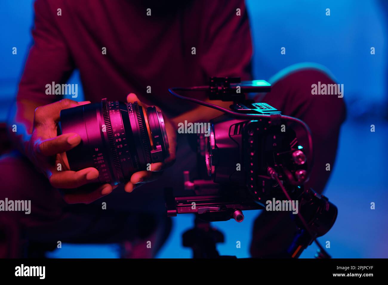 Close-up of African American operator setting his professional camera ...