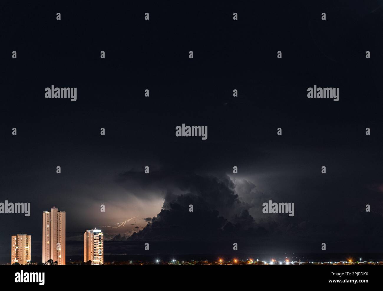 Three Skyscrapers Piercing the Darkened Night Sky During a Thunderstorm ...