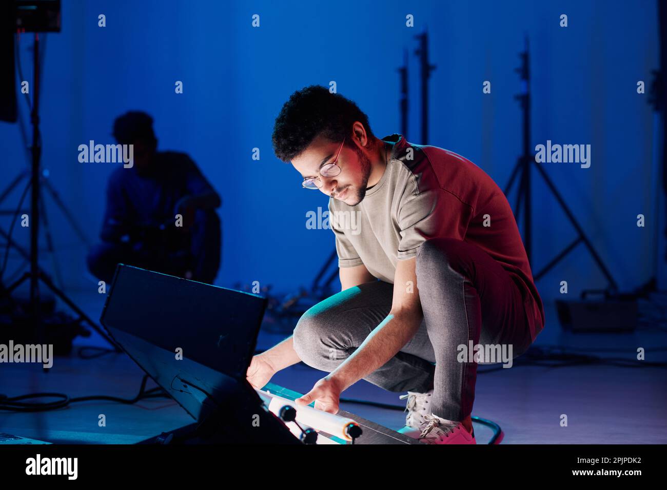 Young man setting the professional light on equipment before shooting ...