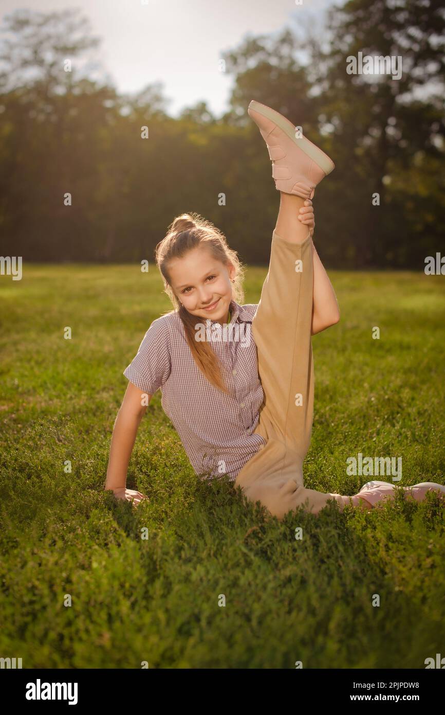 smiling gymnast girl teenager does gymnastics in fresh air and records ...