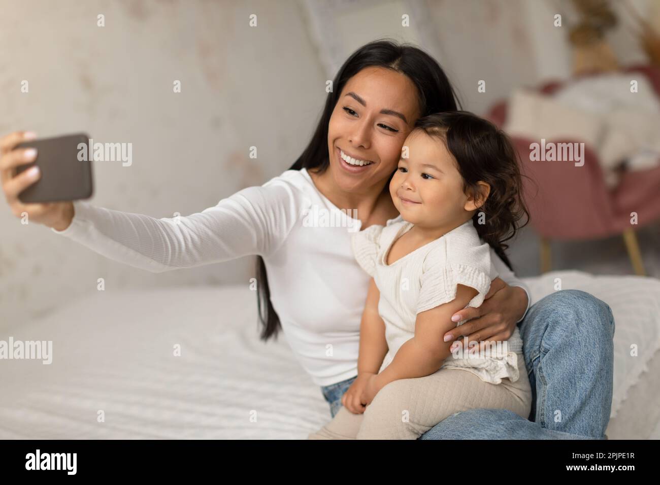 Happy Korean Mom Making Selfie With Baby Daughter At Home Stock Photo ...