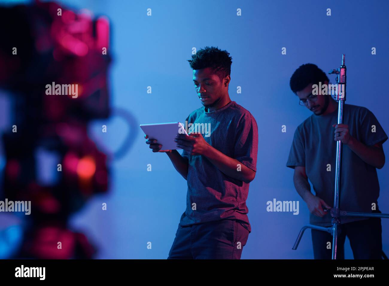 African American young operator examining project on digital tablet ...