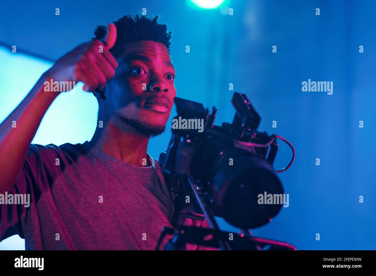 Operator of production studio showing thumb up to his team while ...