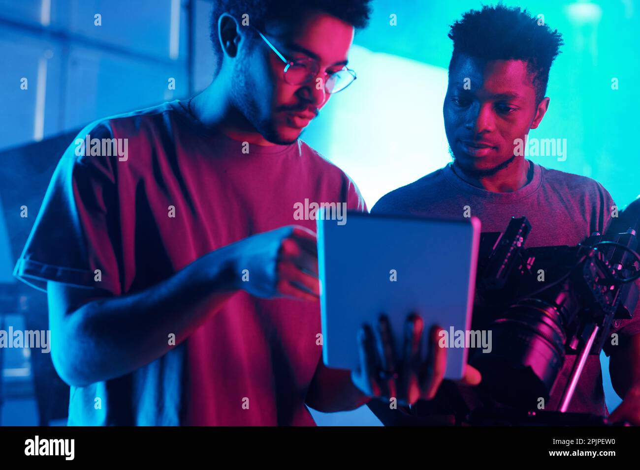 Director showing theme of shooting on digital tablet to photographer ...