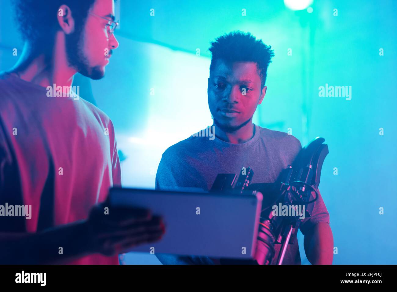 Production director discussing project with operator showing him screen ...