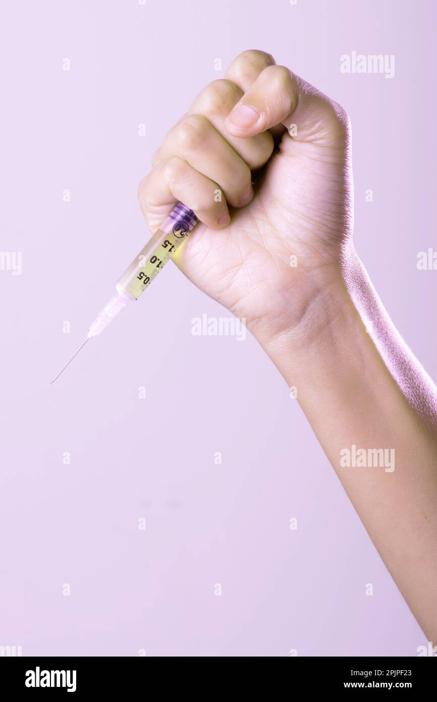 Hand holding drug injection isolated on grey background Stock Photo - Alamy
