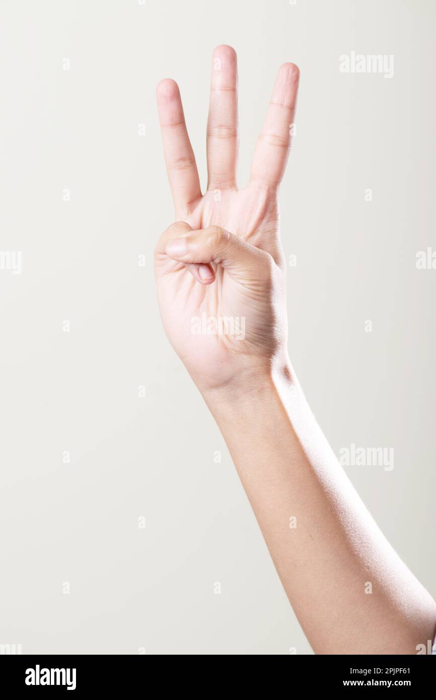 Hand showing three gesture isolated on grey background Stock Photo - Alamy