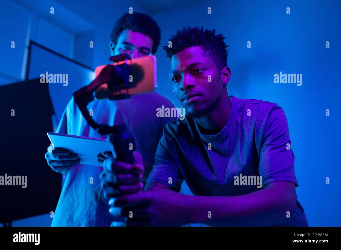 African American operator using smartphone to shoot video with his ...