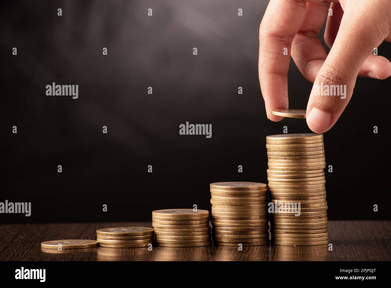 Hand putting coin on black background, money managment concept Stock ...