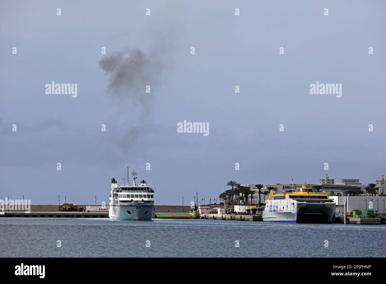 Ship discharging black smoke from funnel at Playa Blanca harbour ...