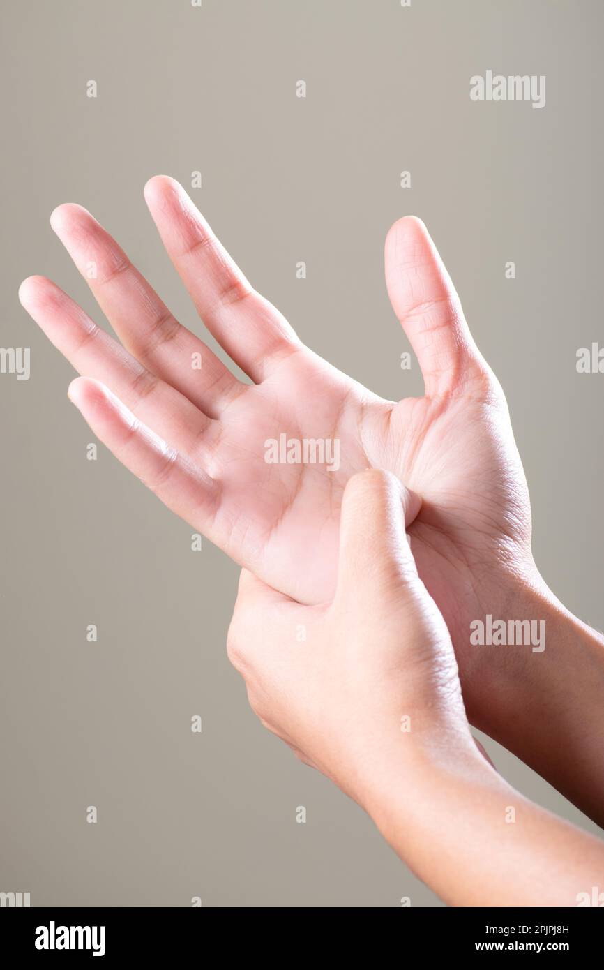 Acupressure point pressing on palm at grey background Stock Photo - Alamy
