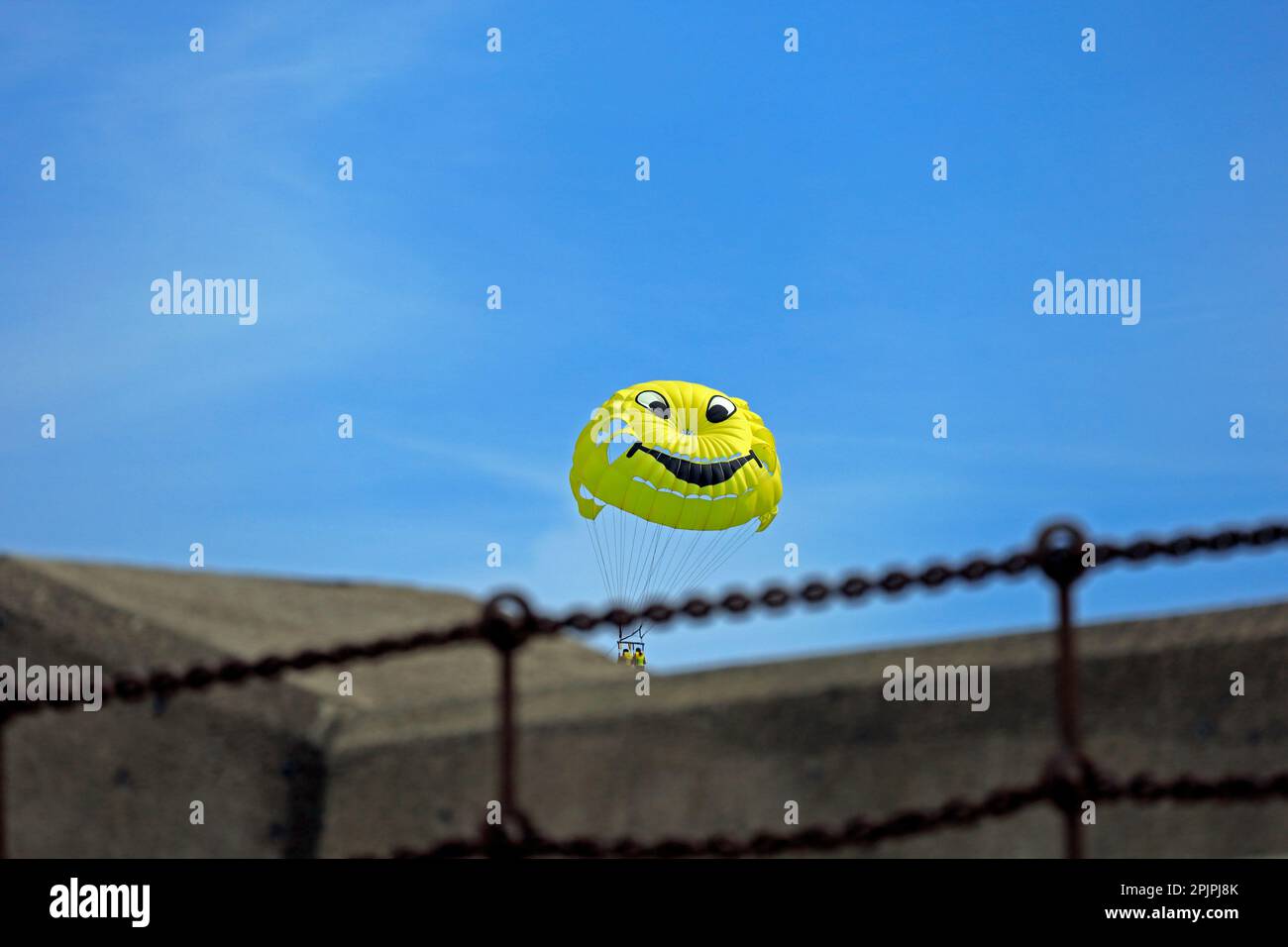 Parasailing. Yellow parachute with a smiley face disappearing over the ...