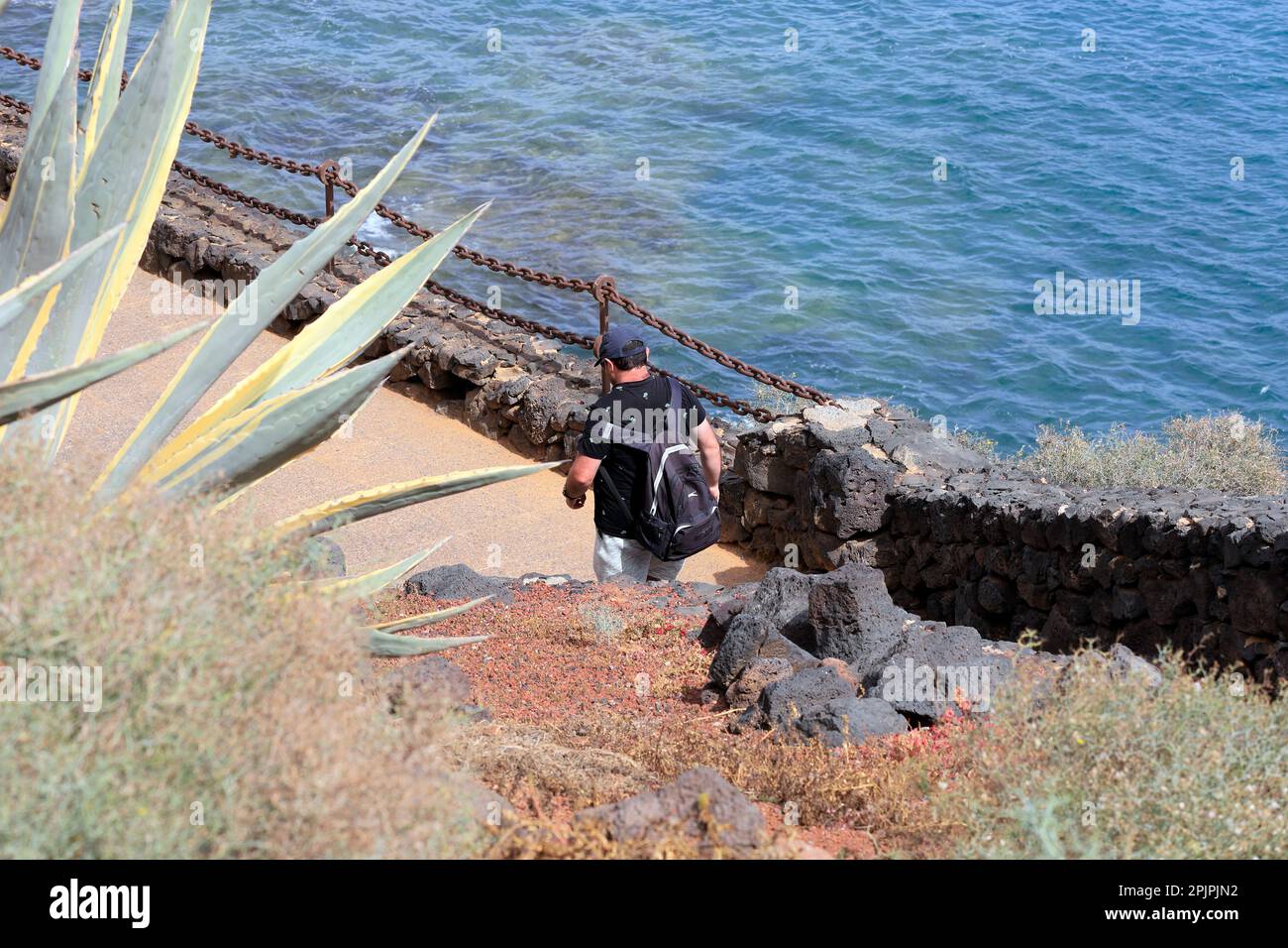 Man enjoying walking on the coastal path between Playa Blanca and Las ...