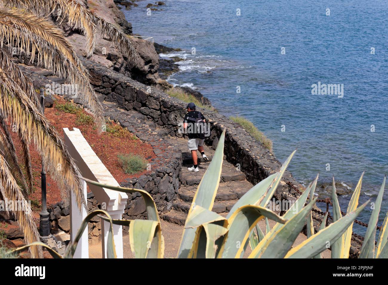 Man enjoying walking on the coastal path between Playa Blanca and Las ...