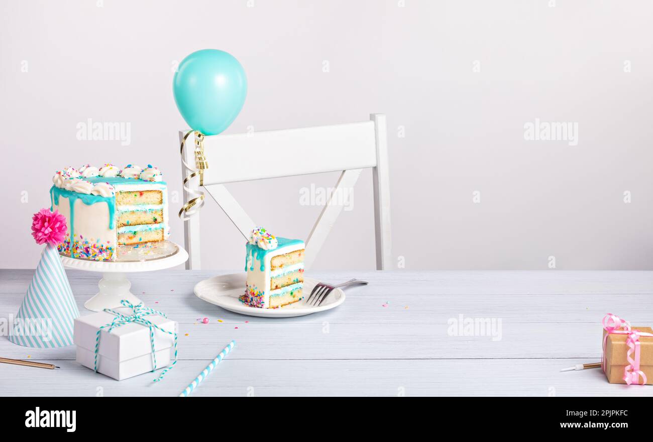 Birthday party table setting with a teal blue ganache drip cake on a ...