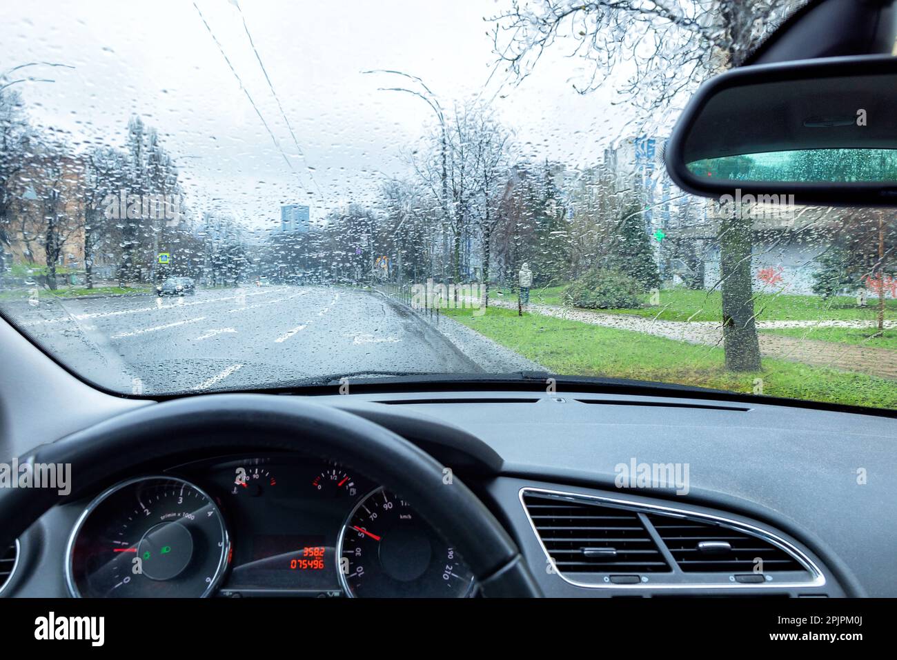 View from the driver - car interior with steering wheel and dashboard ...